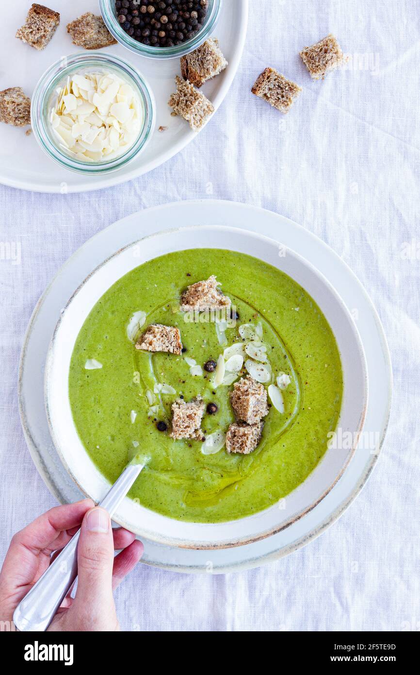 High angle of crop unrecognizable person sitting at table and eating ...
