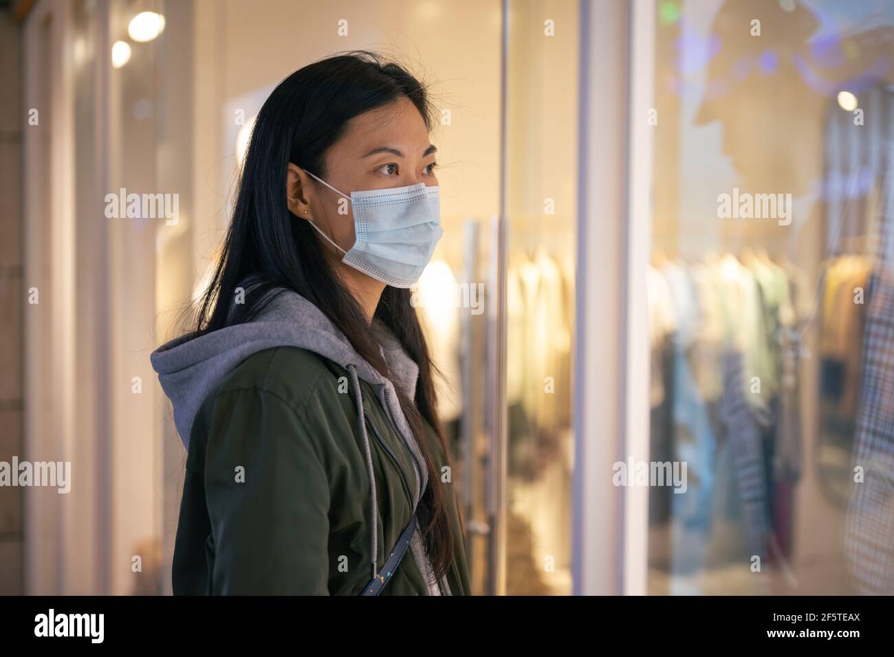 Side view asian girl wearing a mask in front of clothing shop Stock ...