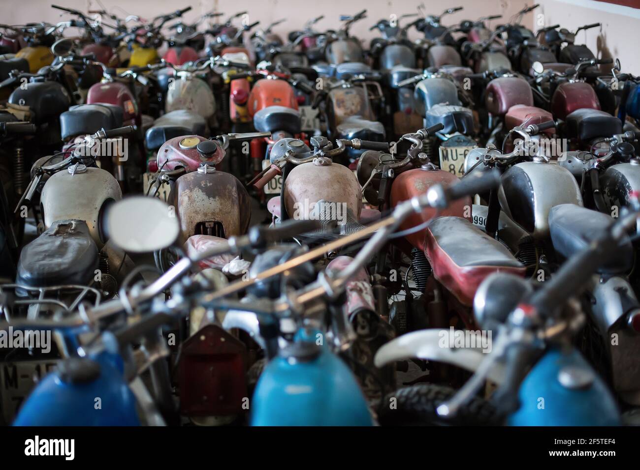 many old fashioned damaged rusty motorcycles placed in rows in repair ...