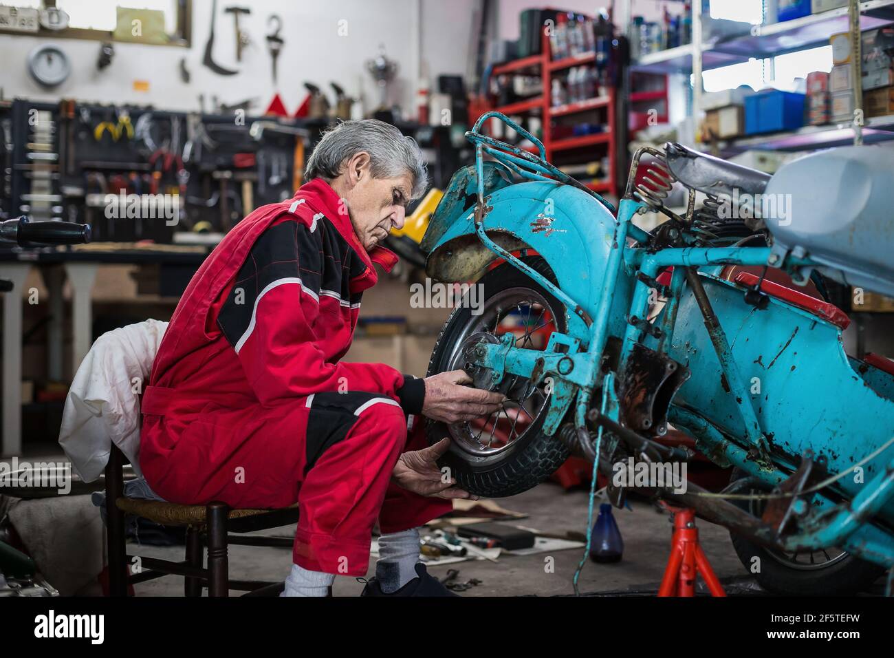 Side view of serious skilled elderly male mechanic in workwear ...