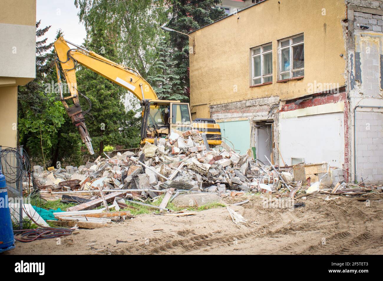 Demolition of old building. Dismantling and crashing house by machinery ...