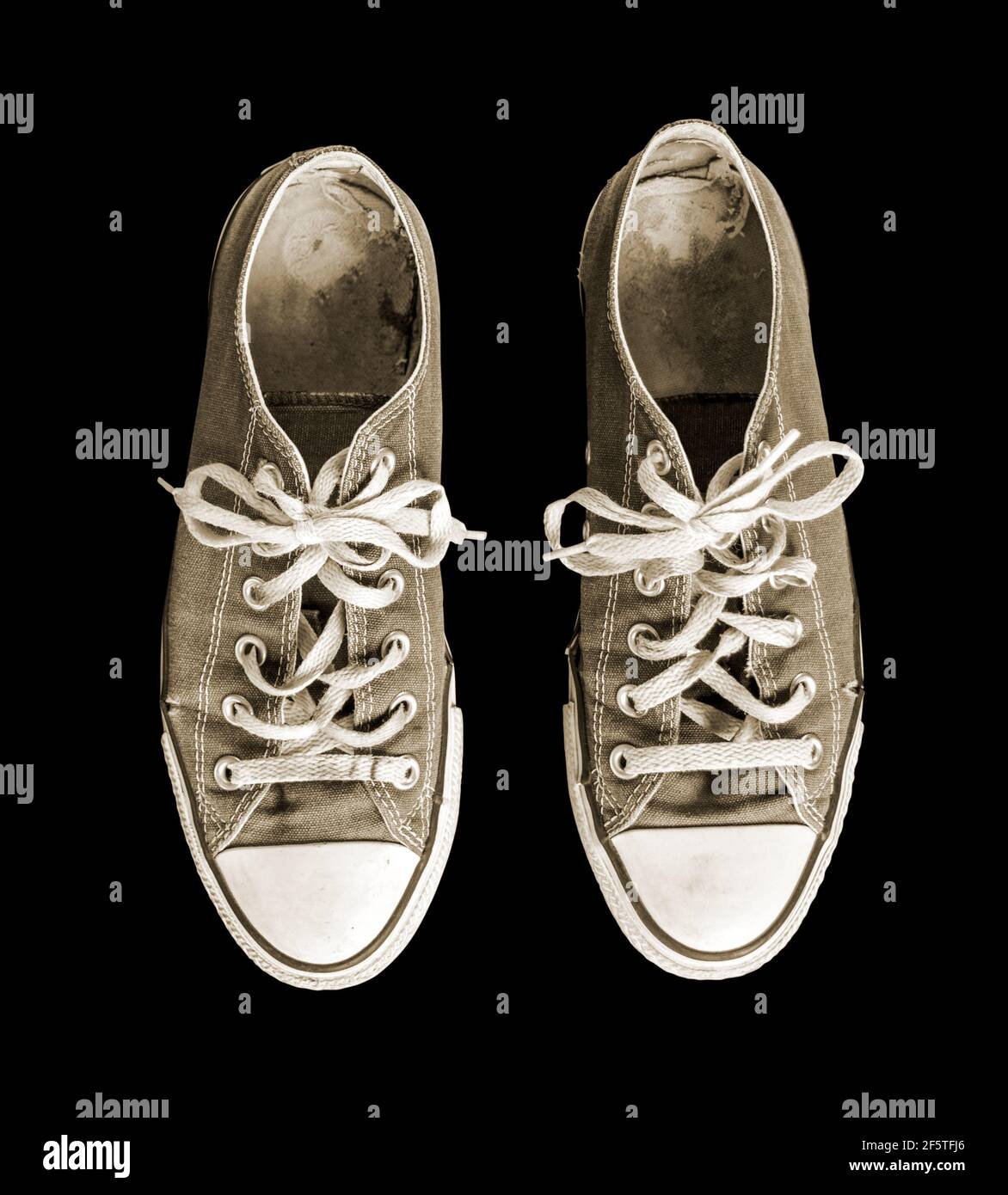 Old generic sneakers isolated on black background Stock Photo - Alamy