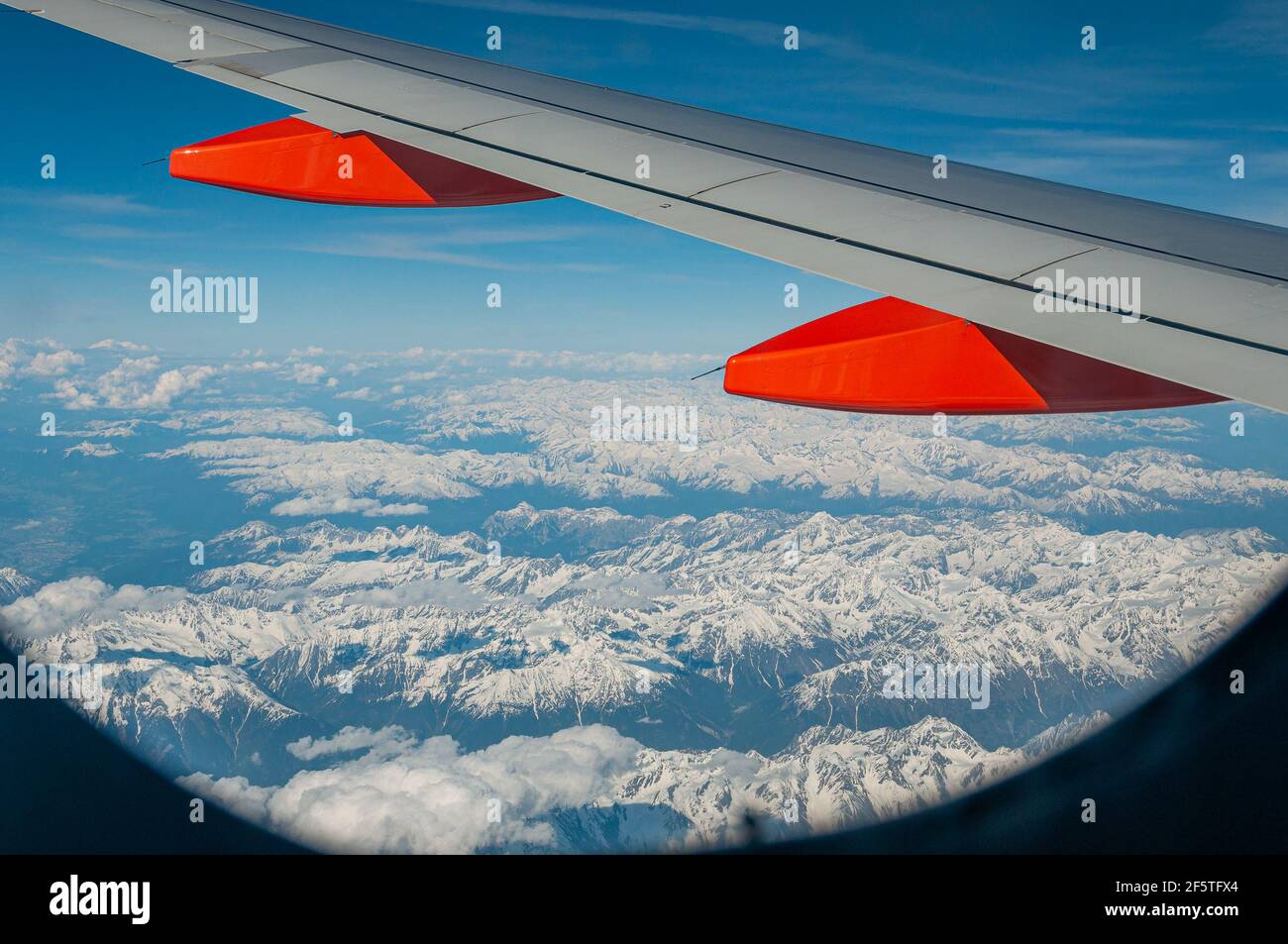 Aerial view of the snow-capped Alps from an airliner porthole. Concept ...