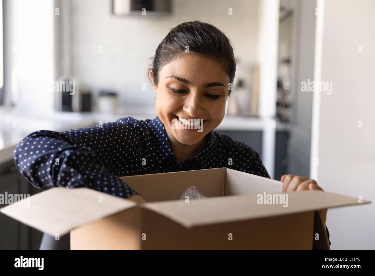 Close up smiling Indian woman opening cardboard box, received parcel ...