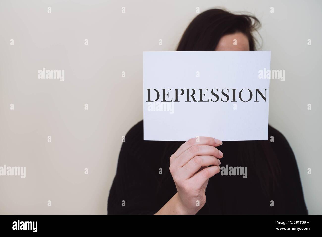 Woman holding white paper sheet card with word DEPRESSION isolated on ...