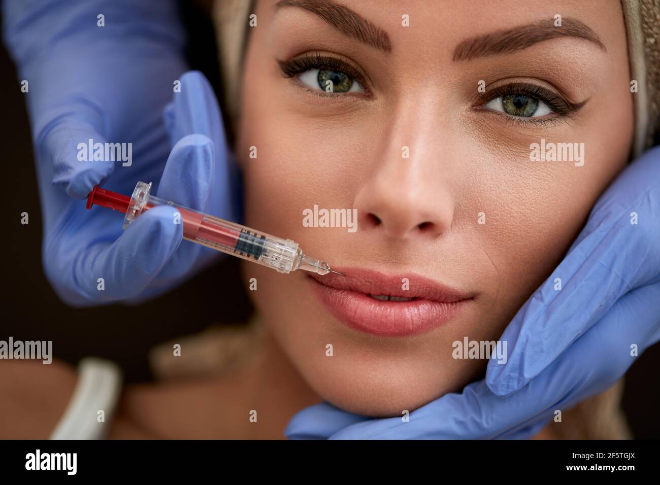 Young beauty woman receiving injections in lips. Plastic surgery Stock ...