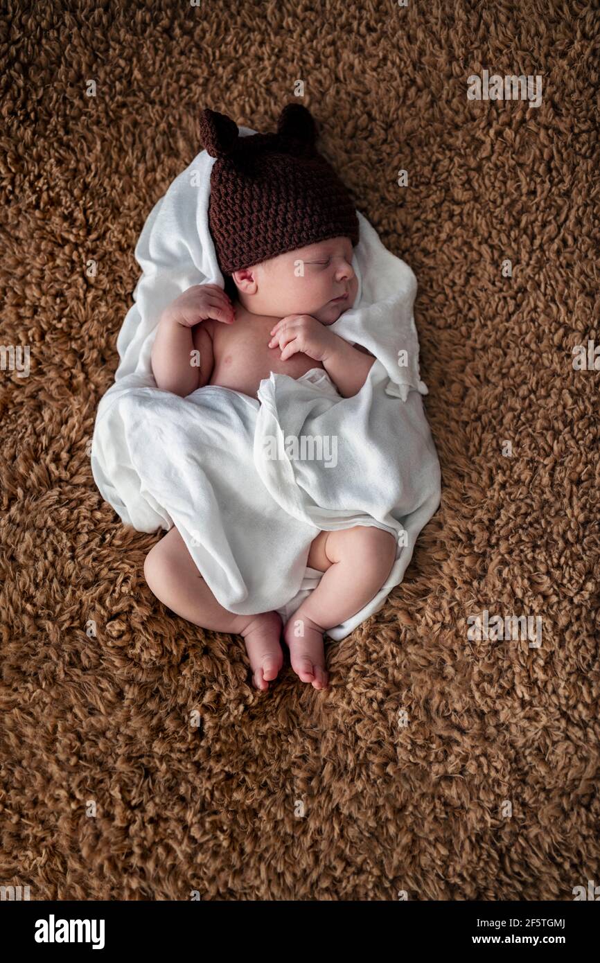 Serenity very little baby sleeping, newborn boy with funny woolen hat ...