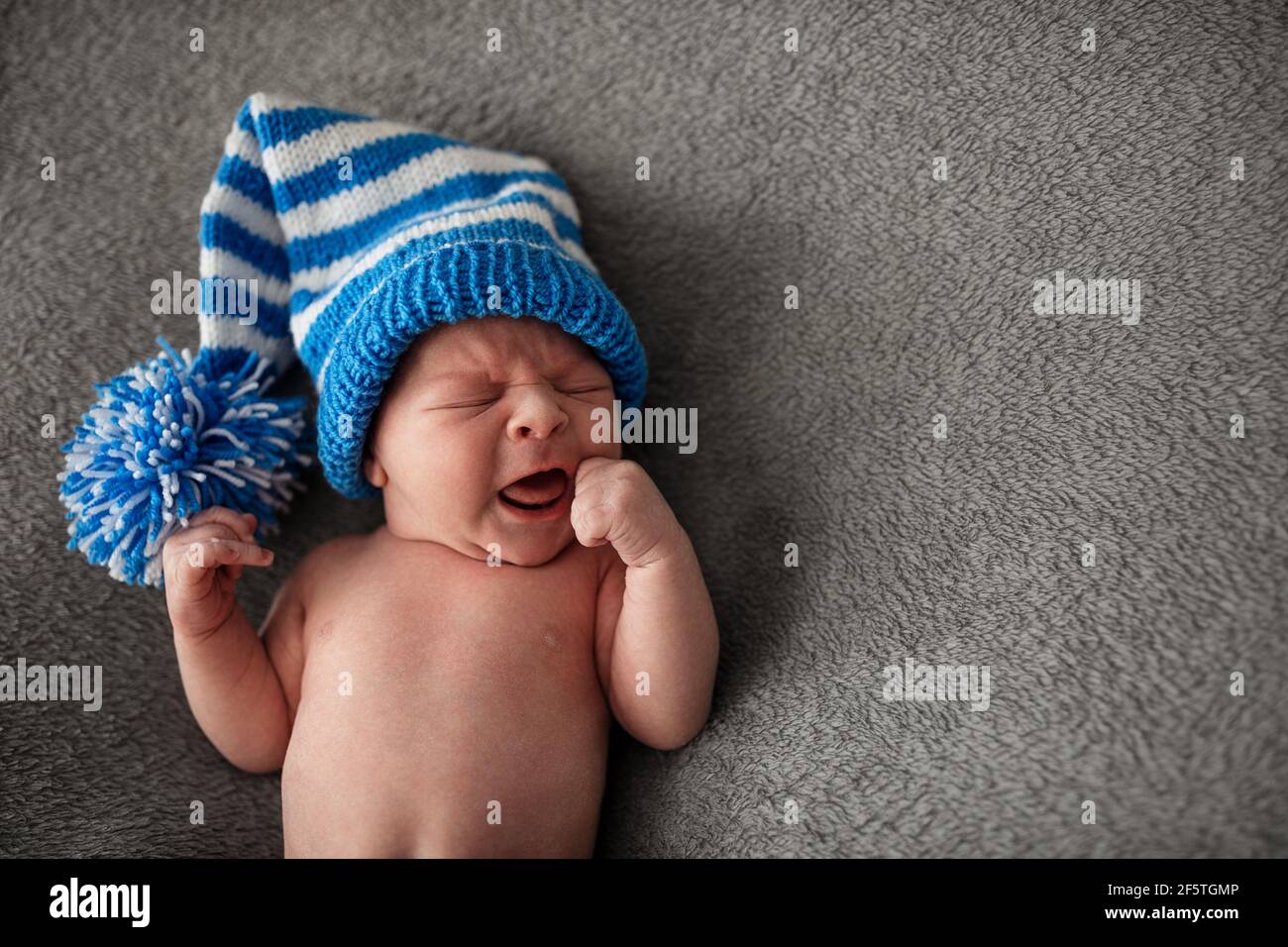 little newborn baby very unsatisfied crying on bed Stock Photo - Alamy