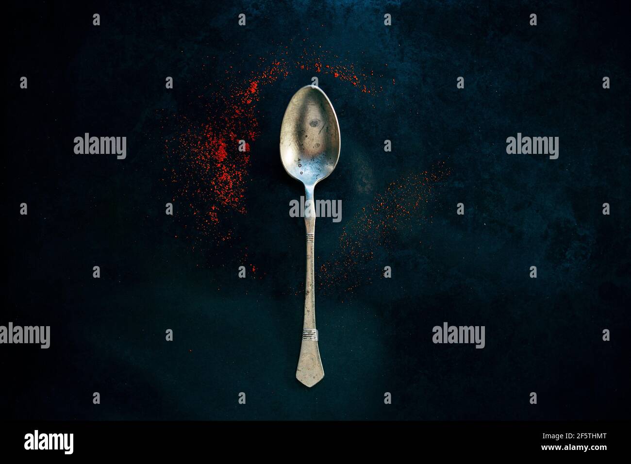 Vintage old teaspoon laying on dark background surrounded with red ...