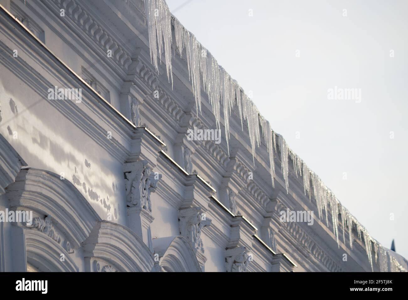 Icicles on building roof. Danger of falling icicle Stock Photo - Alamy