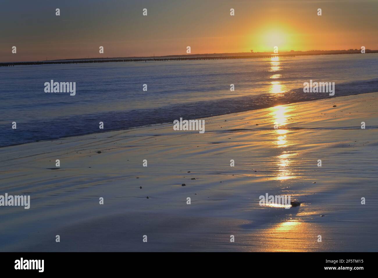 beautiful sunset reflecting on the sea and wet sand in atlantic ocean ...