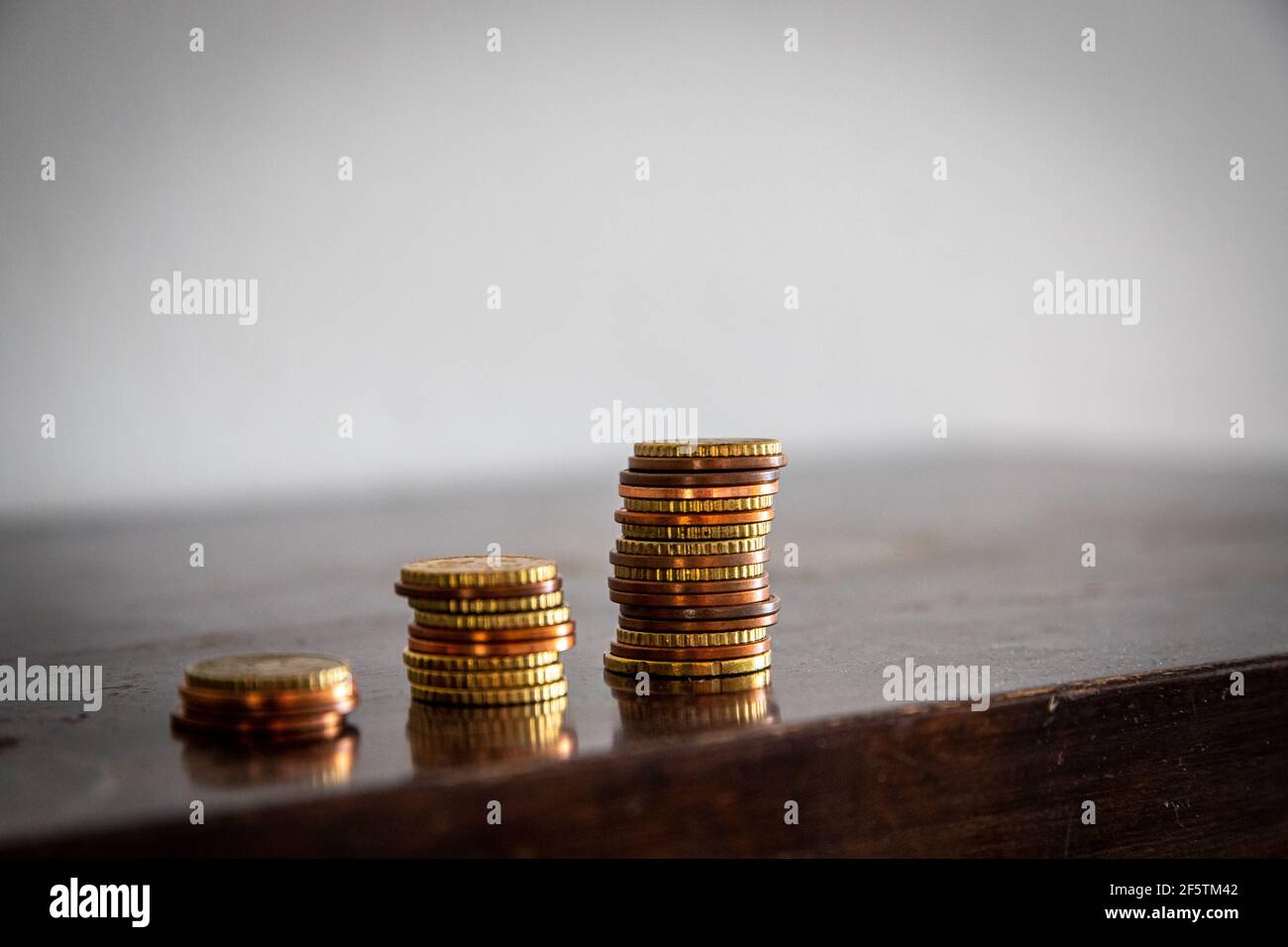 A closeup shot of coins rows on a wooden table - savings concept Stock ...