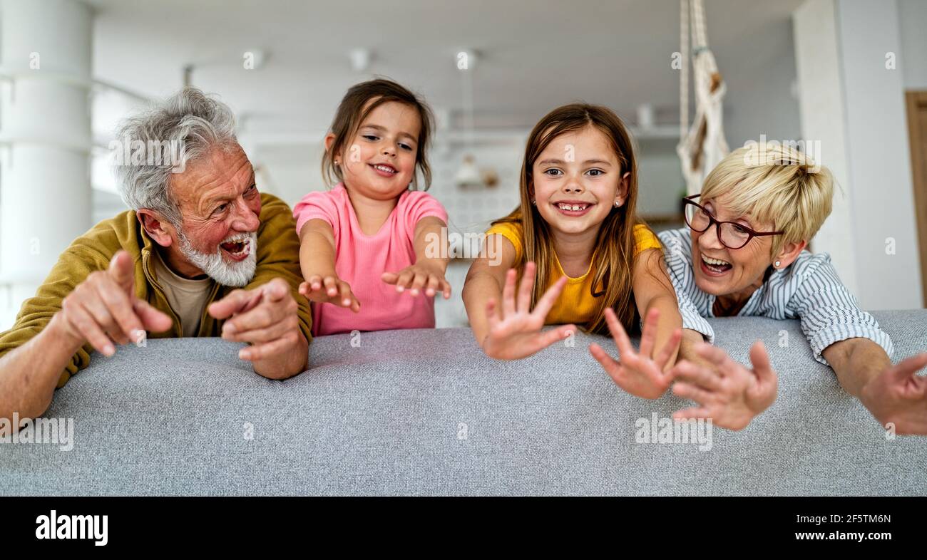 Grandchildren having fun at home while playing with their grandparents ...