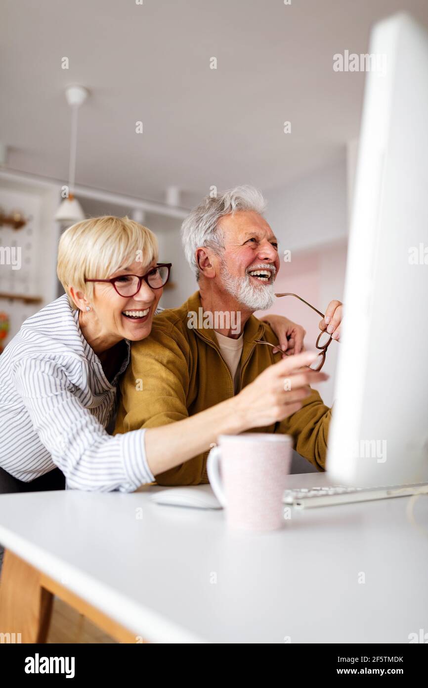 Senior woman helping senior man to use computer Stock Photo - Alamy