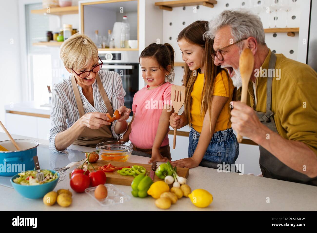 Cheerful family spending good time together while cooking in kitchen ...