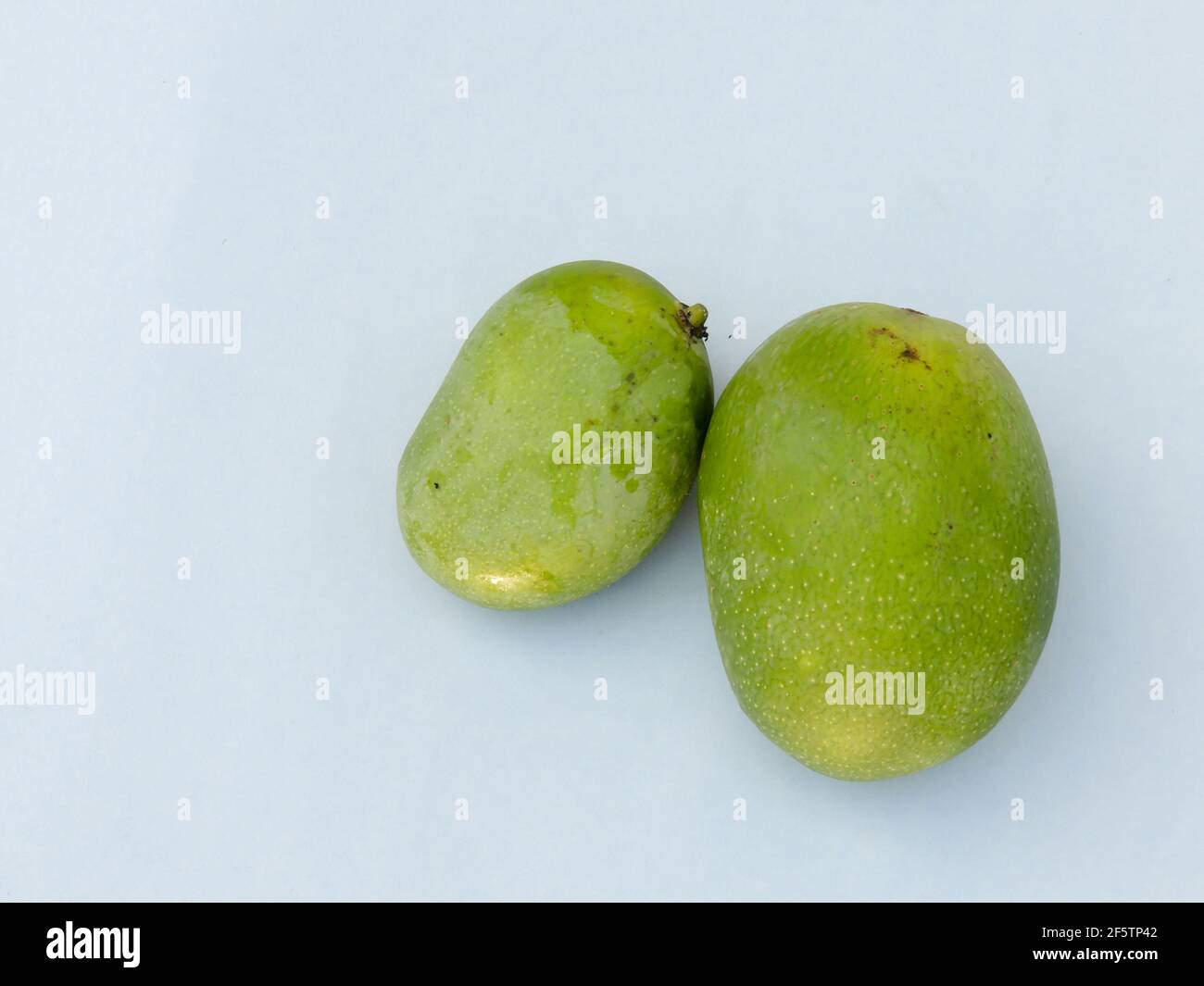 A top view of green mangoes on a plain background Stock Photo - Alamy