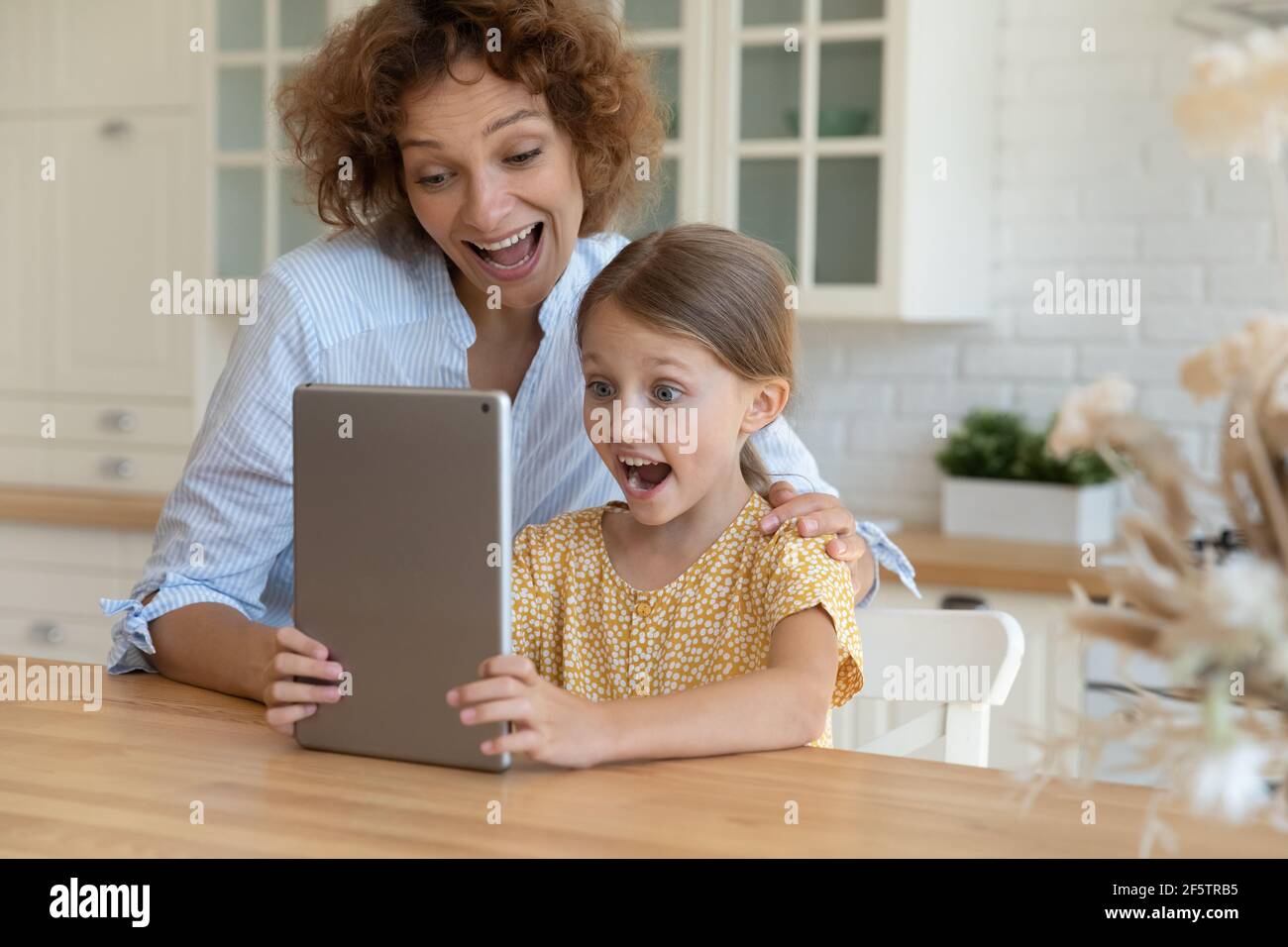 Amazed mom and little daughter feel shocked using tablet Stock Photo ...