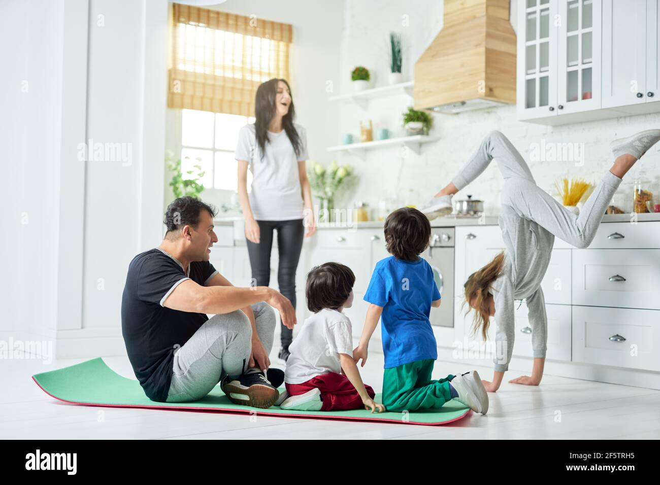Exercising together. Full length shot of happy latin family having ...