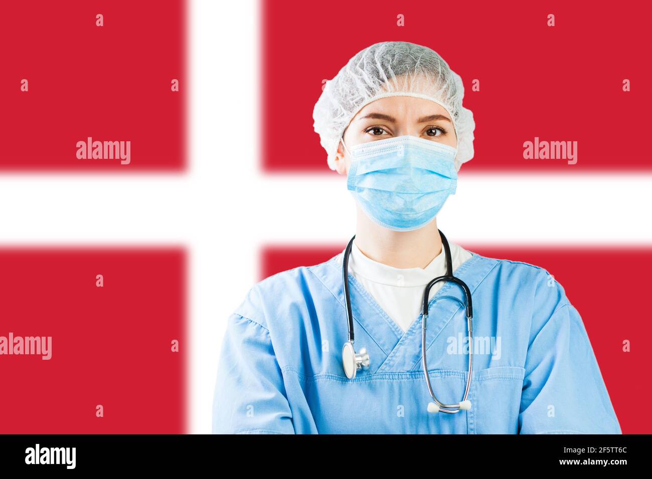 Portrait of a caucasian doctor with flag of Denmark in background ...