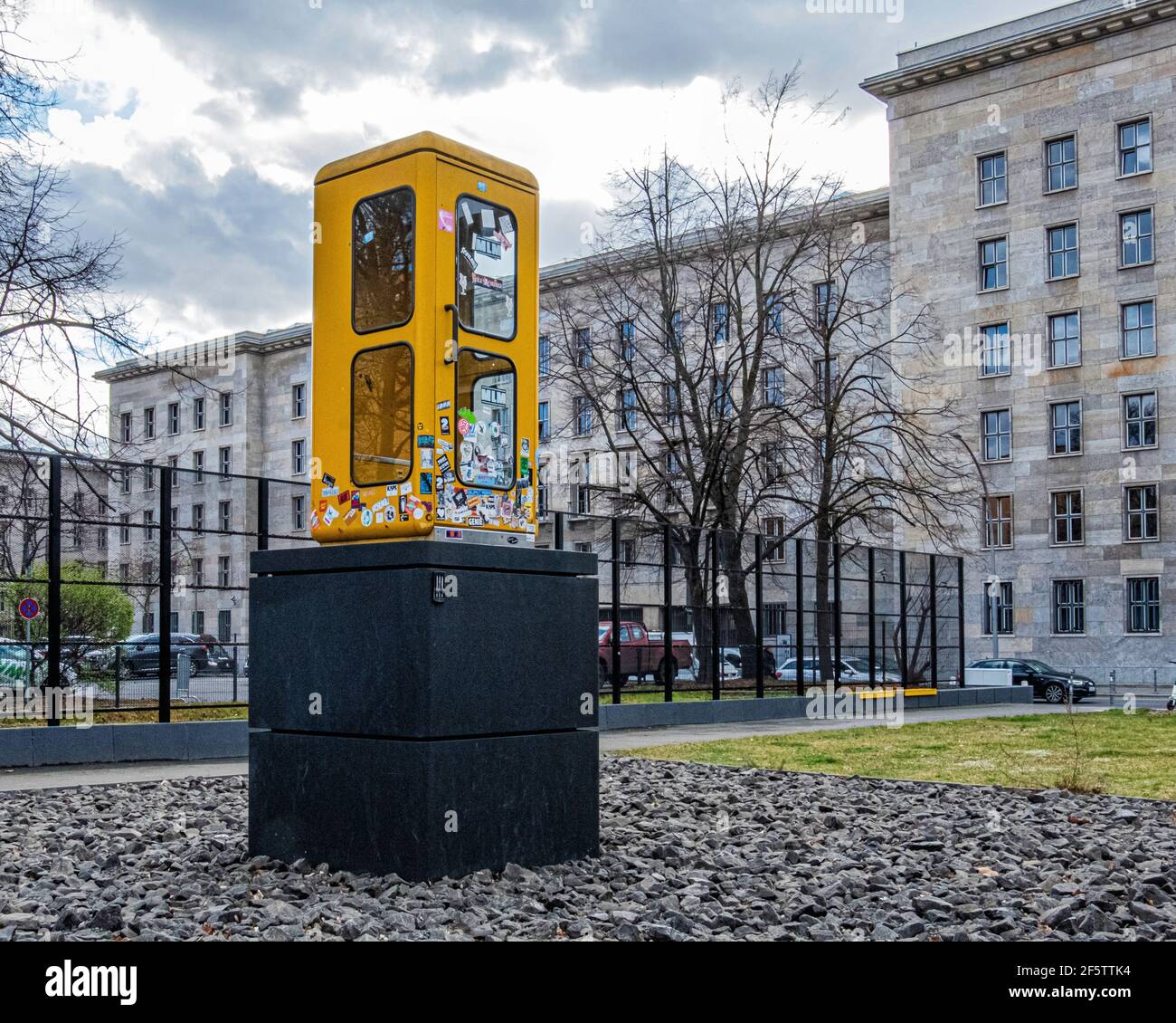 Old yellow phone box on black plinth at Berlin Phone Booth Memorial ...