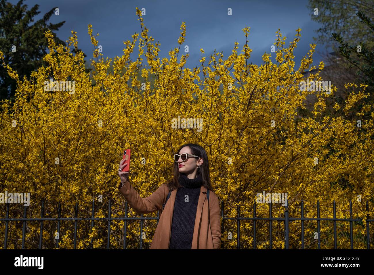 London, UK. 28th March, 2021. UK Weather: A young woman takes a selfie ...