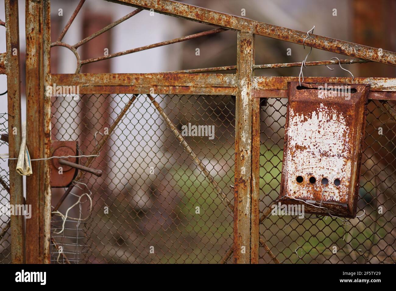 old rusty mailbox hanging on a rural fence mesh with newspaper Stock ...