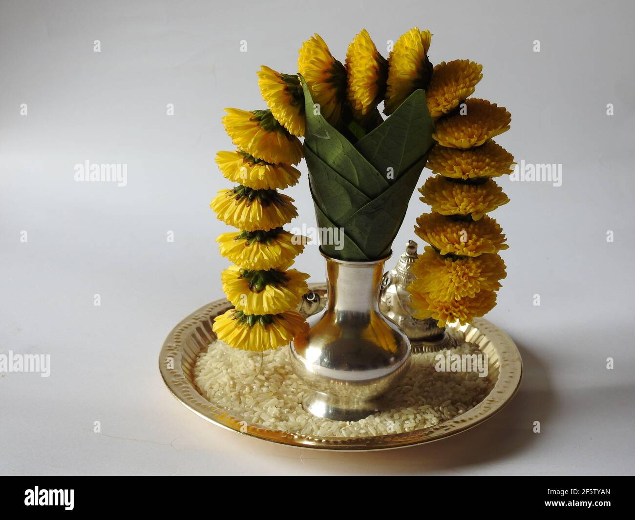 A silver Kalash with chrysanthemum flowers, leaves, kumkum, turmeric ...