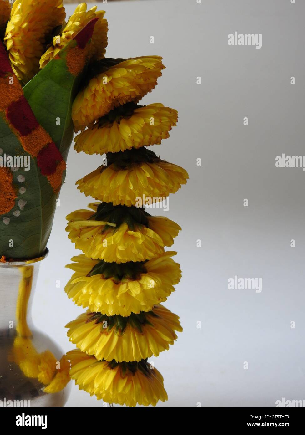 A silver Kalash with chrysanthemum flowers, leaves, kumkum, turmeric ...