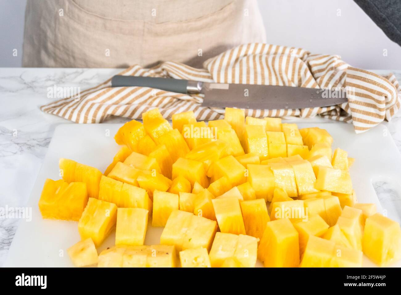 Cleaning and cutting a pineapple into the small pieces Stock Photo - Alamy