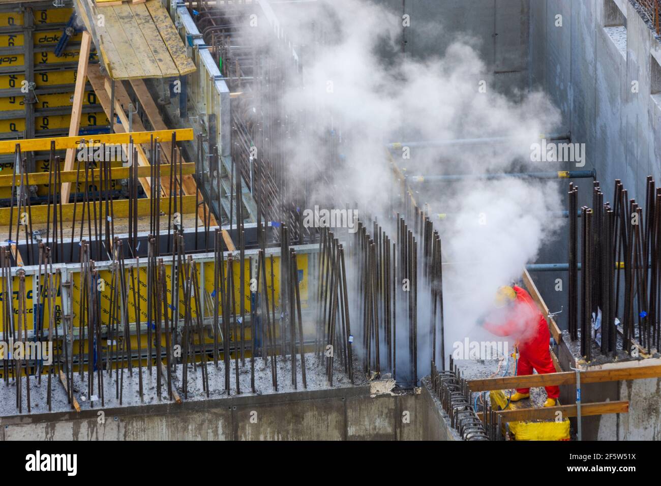 construction worker cleaning concrete at construction site with steam ...