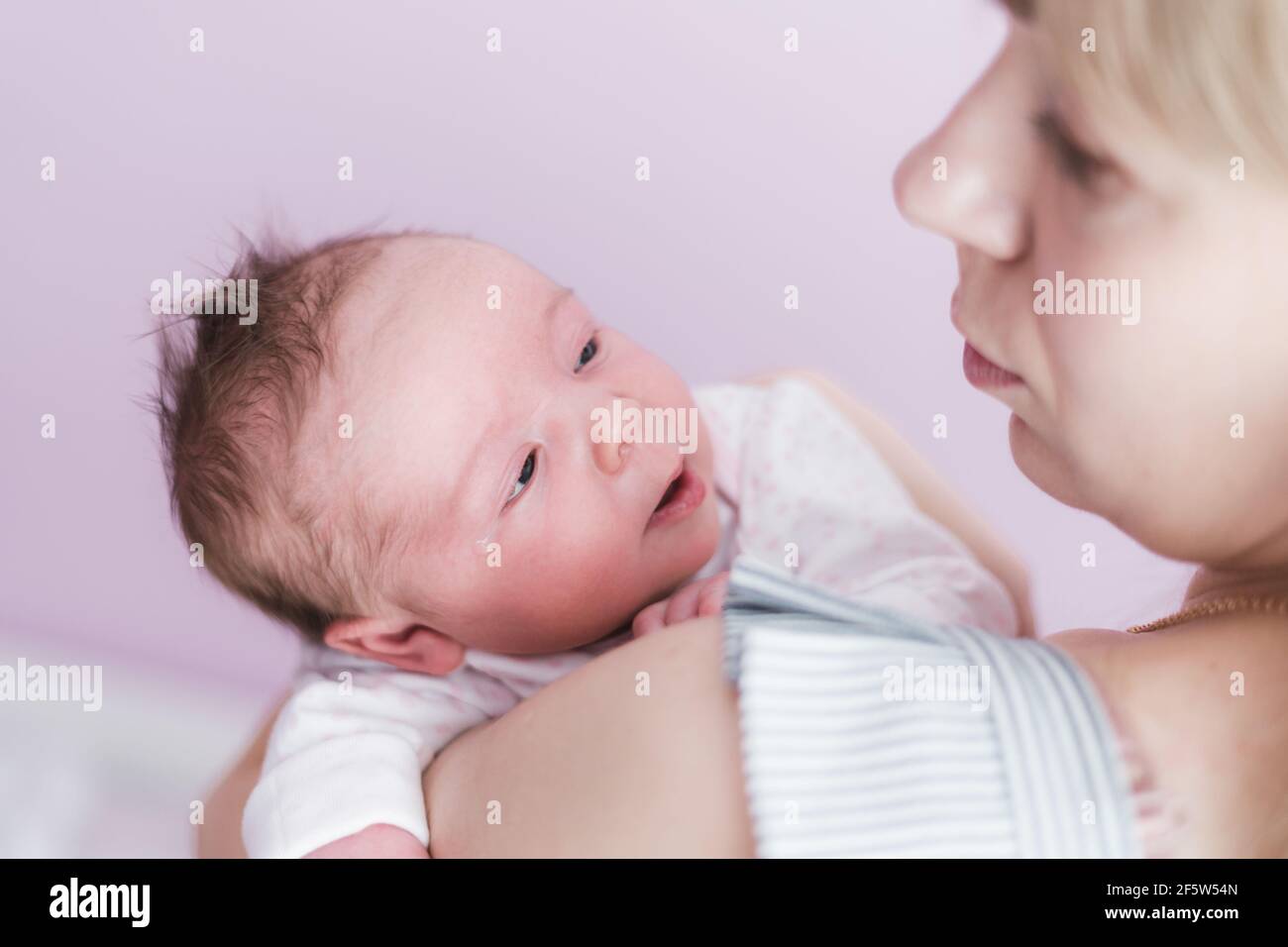 Lifestyle portrait of a young mother and her newborn, three weeks old ...