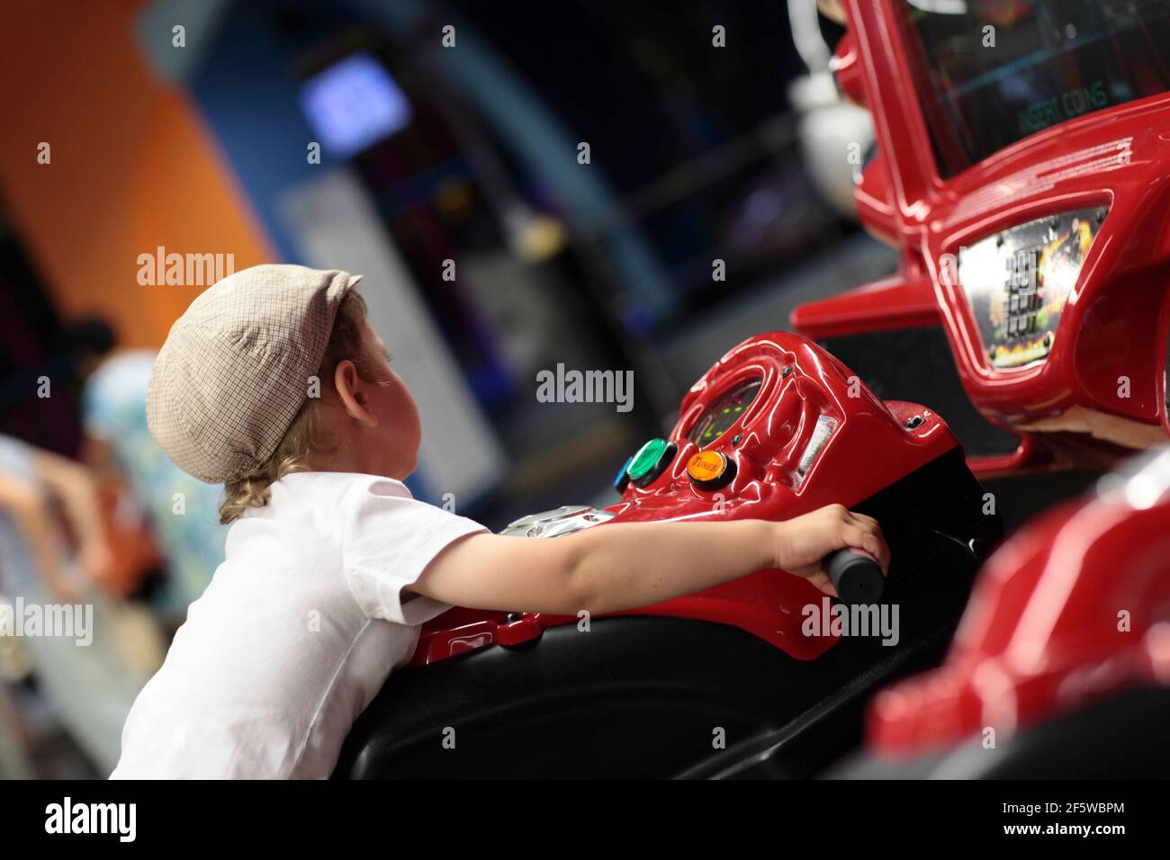 Kid playing arcade simulator machine at an amusement park Stock Photo ...