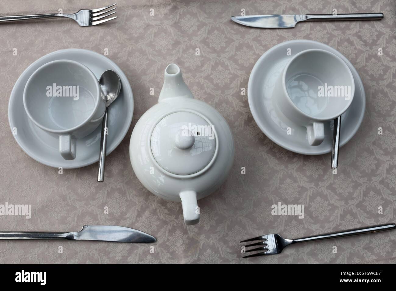 Two teacups and teapot on a dining table Stock Photo - Alamy