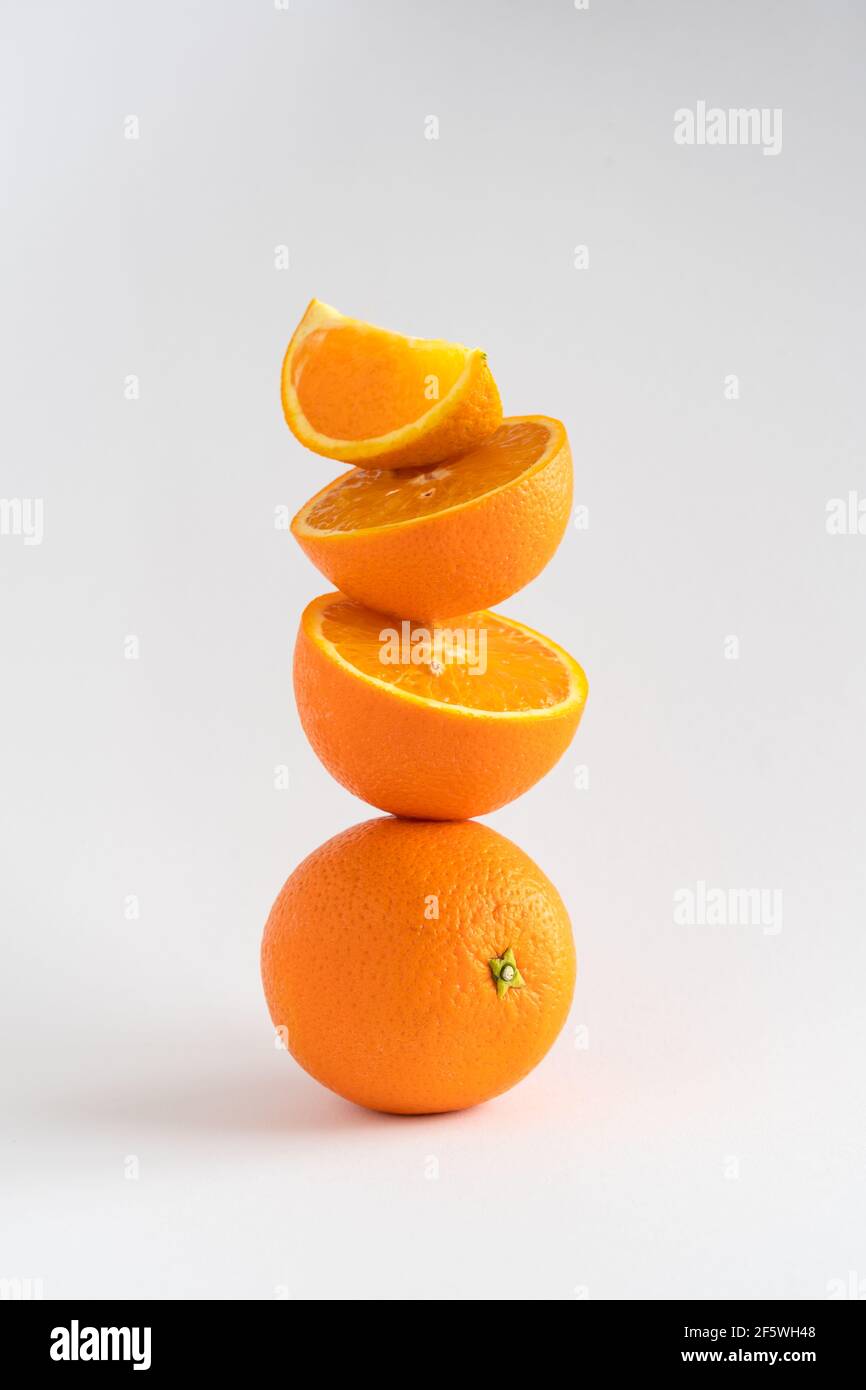 Close-up of a stack of oranges, whole and sliced, a tower of oranges on ...