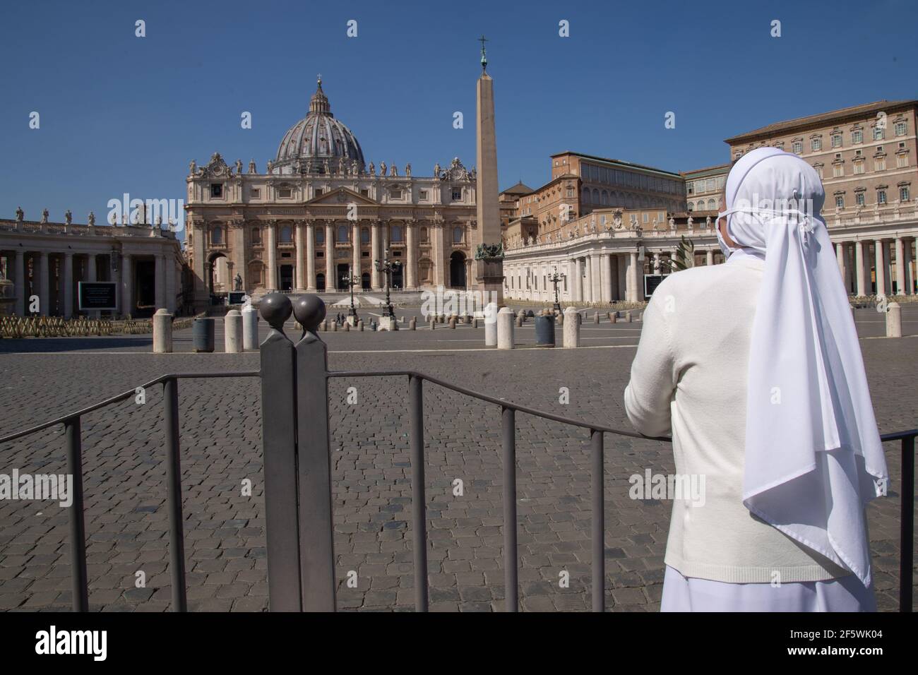 A nun with an olive branch prays on Palm Sunday in St. Peter's Square ...