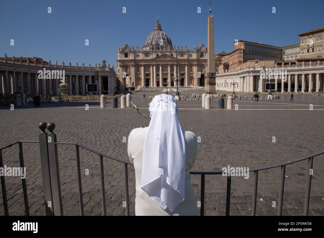 A nun with an olive branch prays on Palm Sunday in St. Peter's Square ...