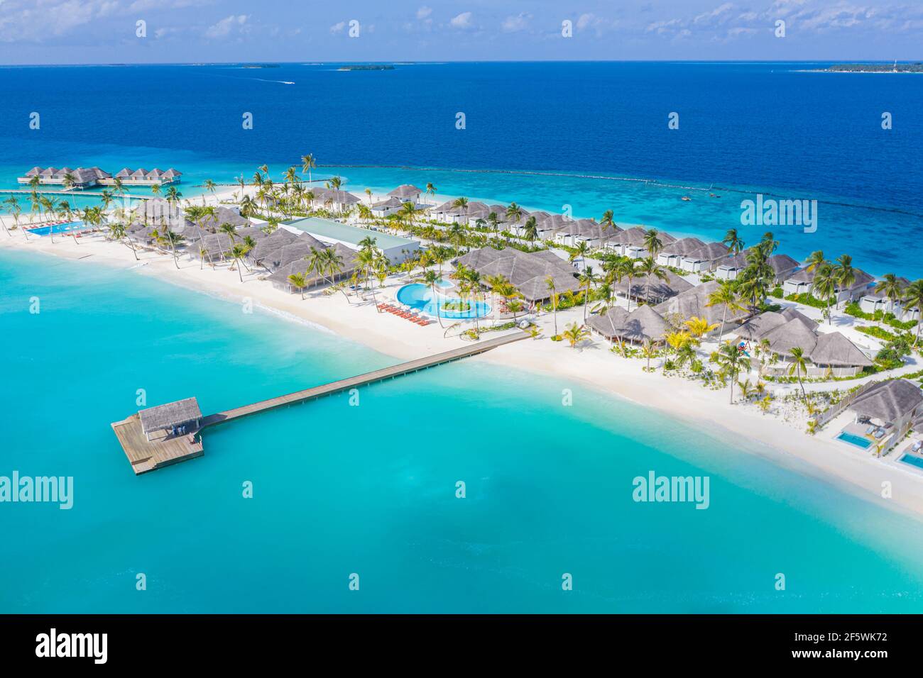 Aerial view of Maldives island, luxury water villas resort and wooden ...