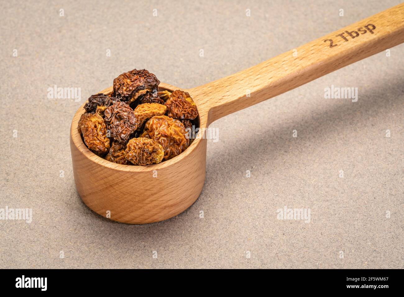dried goldenberry berries in wooden measuring scoop (2 tablespoons ...