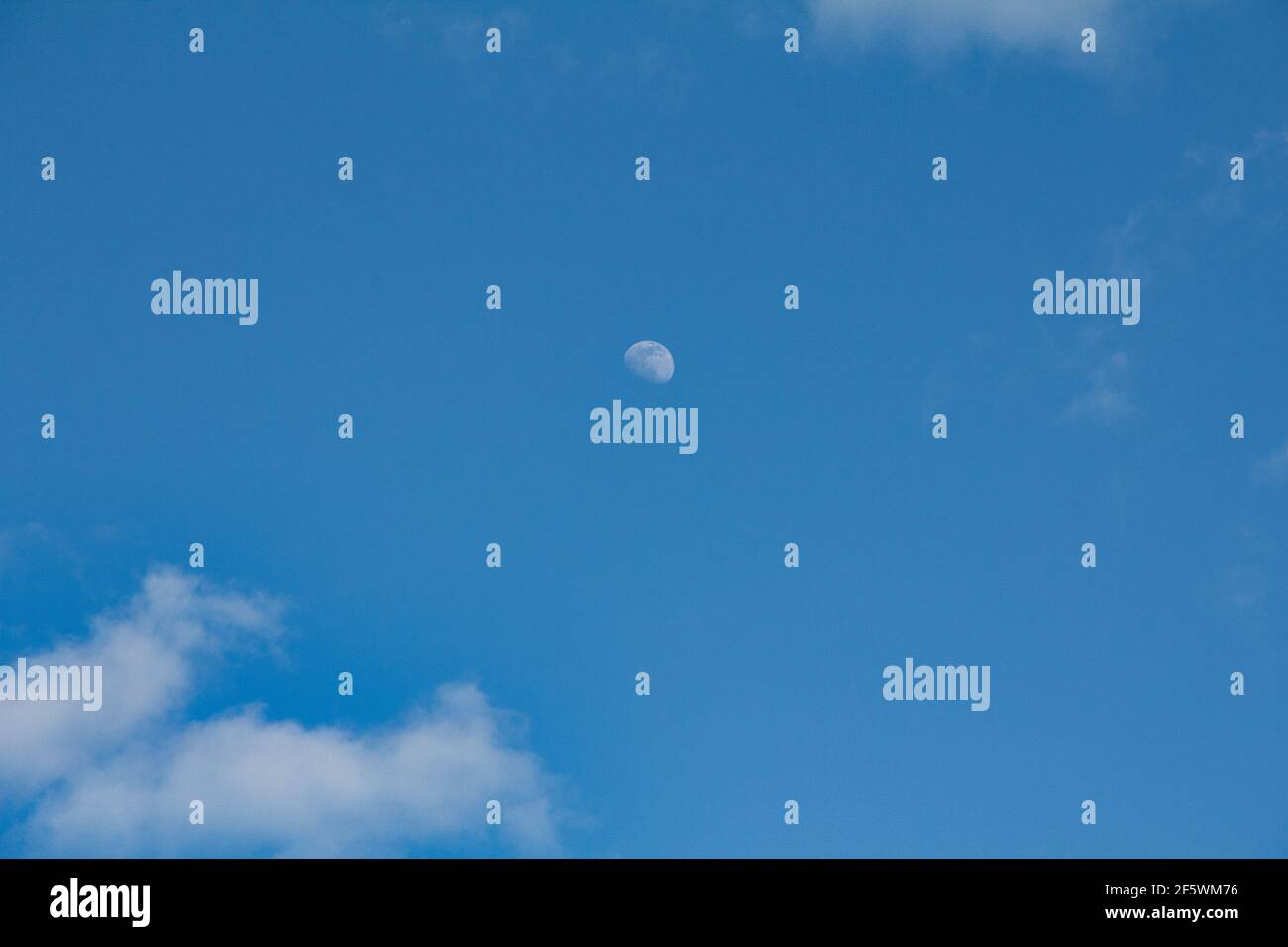day time moon against bright blue sky Stock Photo - Alamy