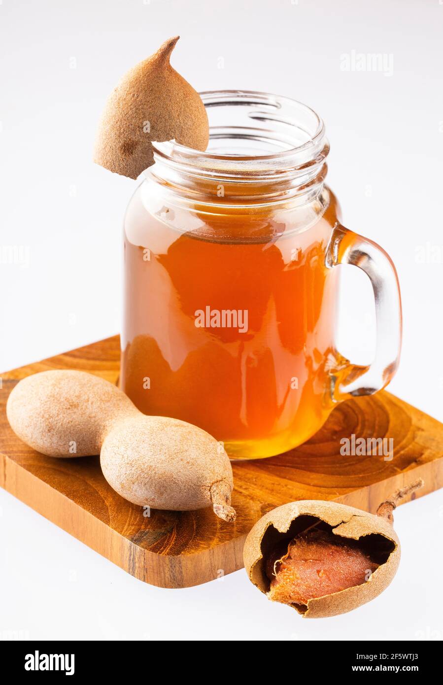Tamarind juice in a glass surrounded by fresh ripe tamarinds Stock ...