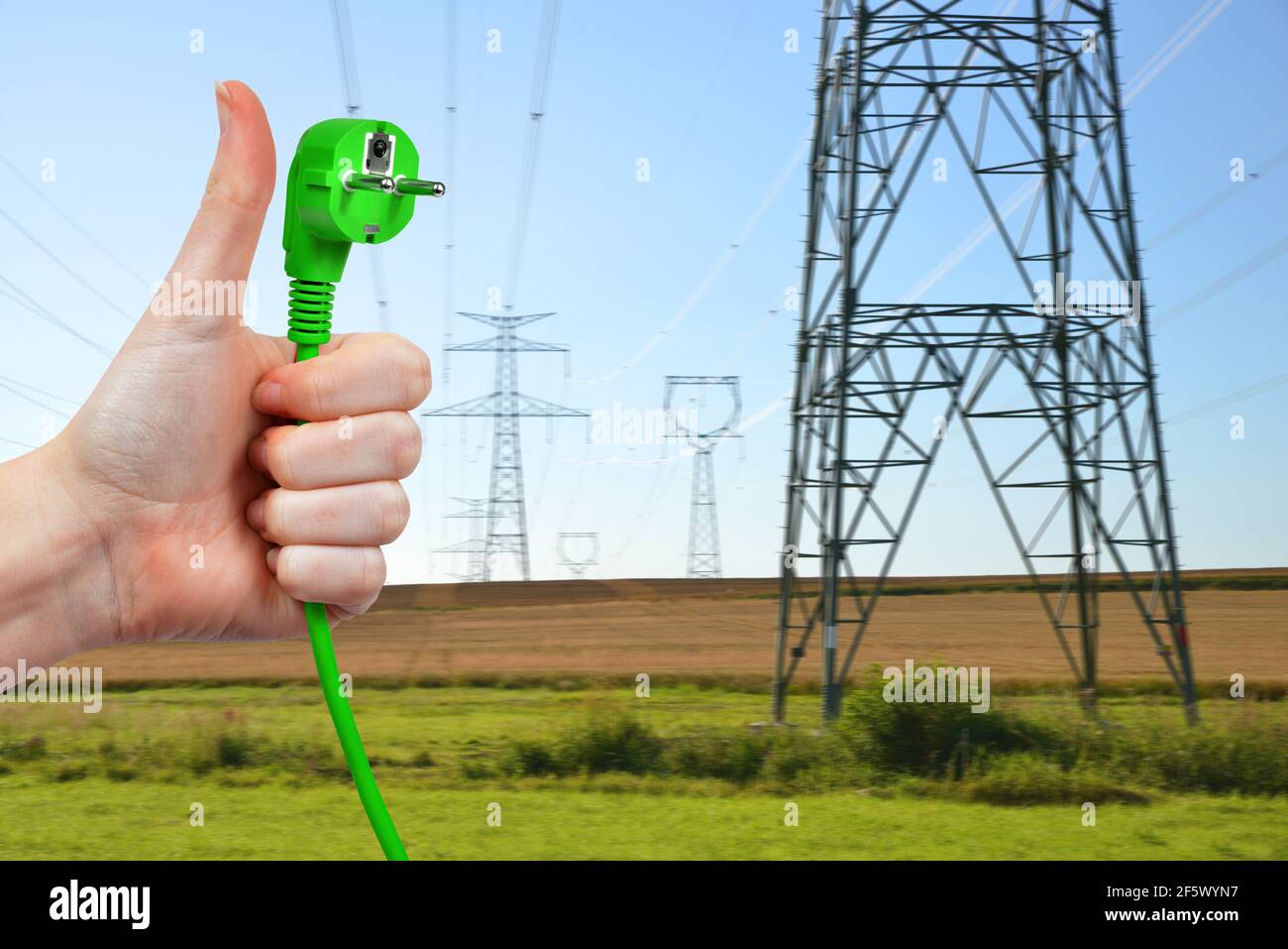 Hand holding electric plug on the background electricity transmission ...