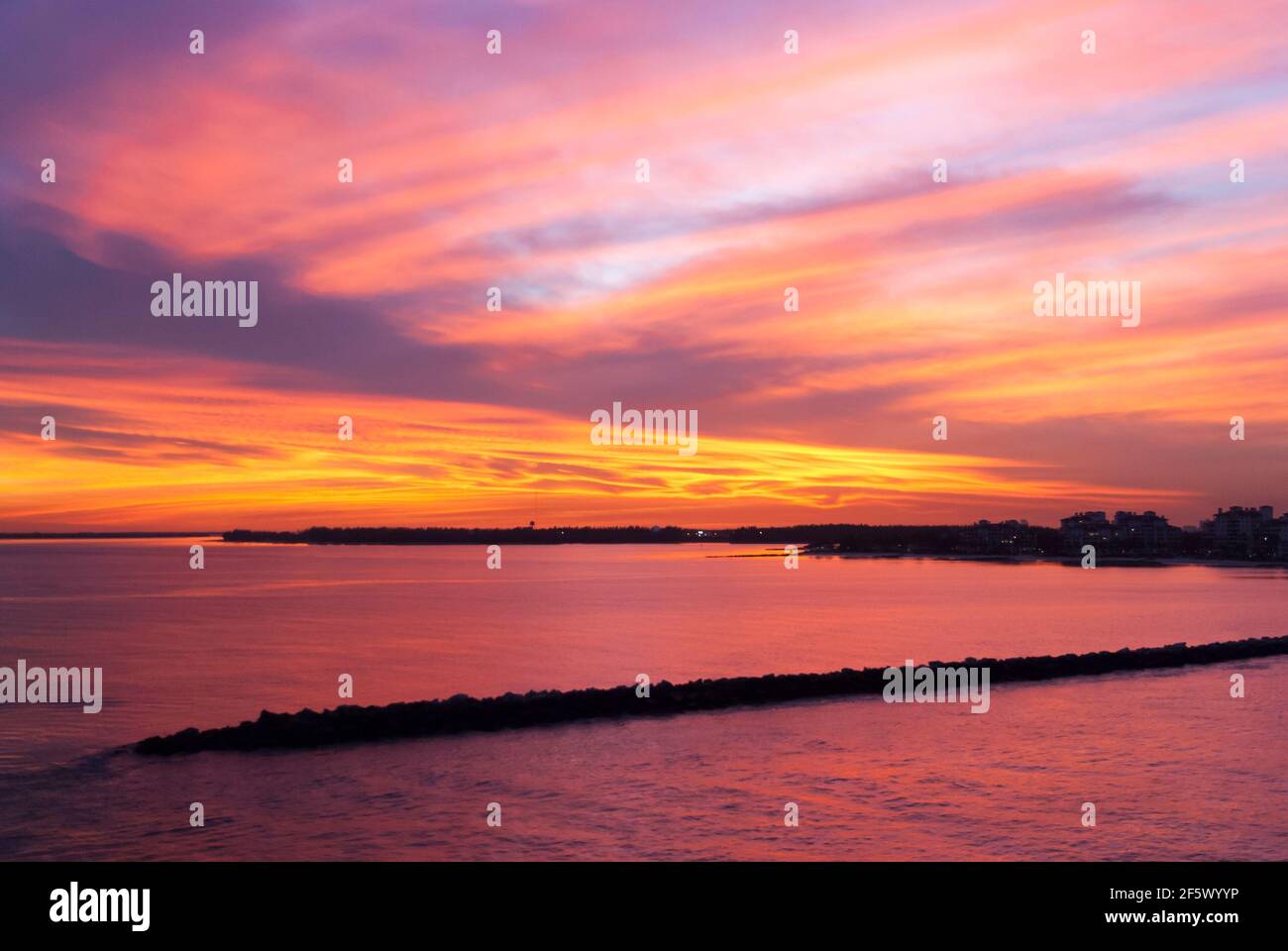 The dramatic red color sunset sky and the ocean with Fisher Island in a ...