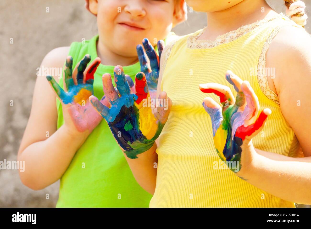 Two happy creative school age children, colorful painted hands, kids ...