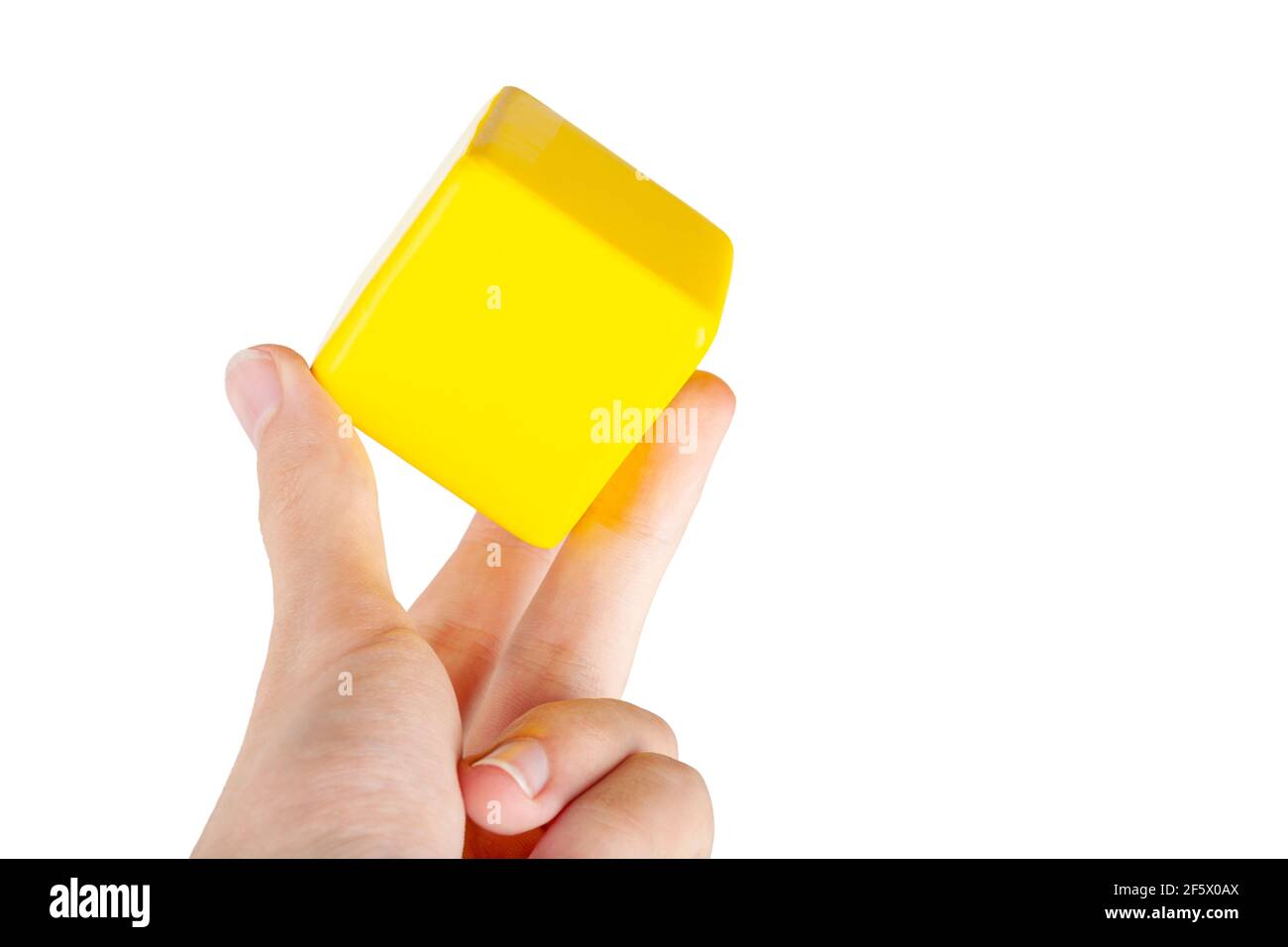 Hand holding up a simple plain yellow floating hovering cube element or ...