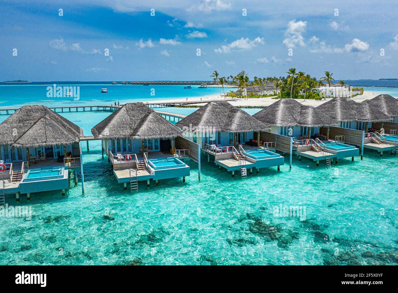 Aerial view of Maldives island, luxury water villas resort and wooden ...