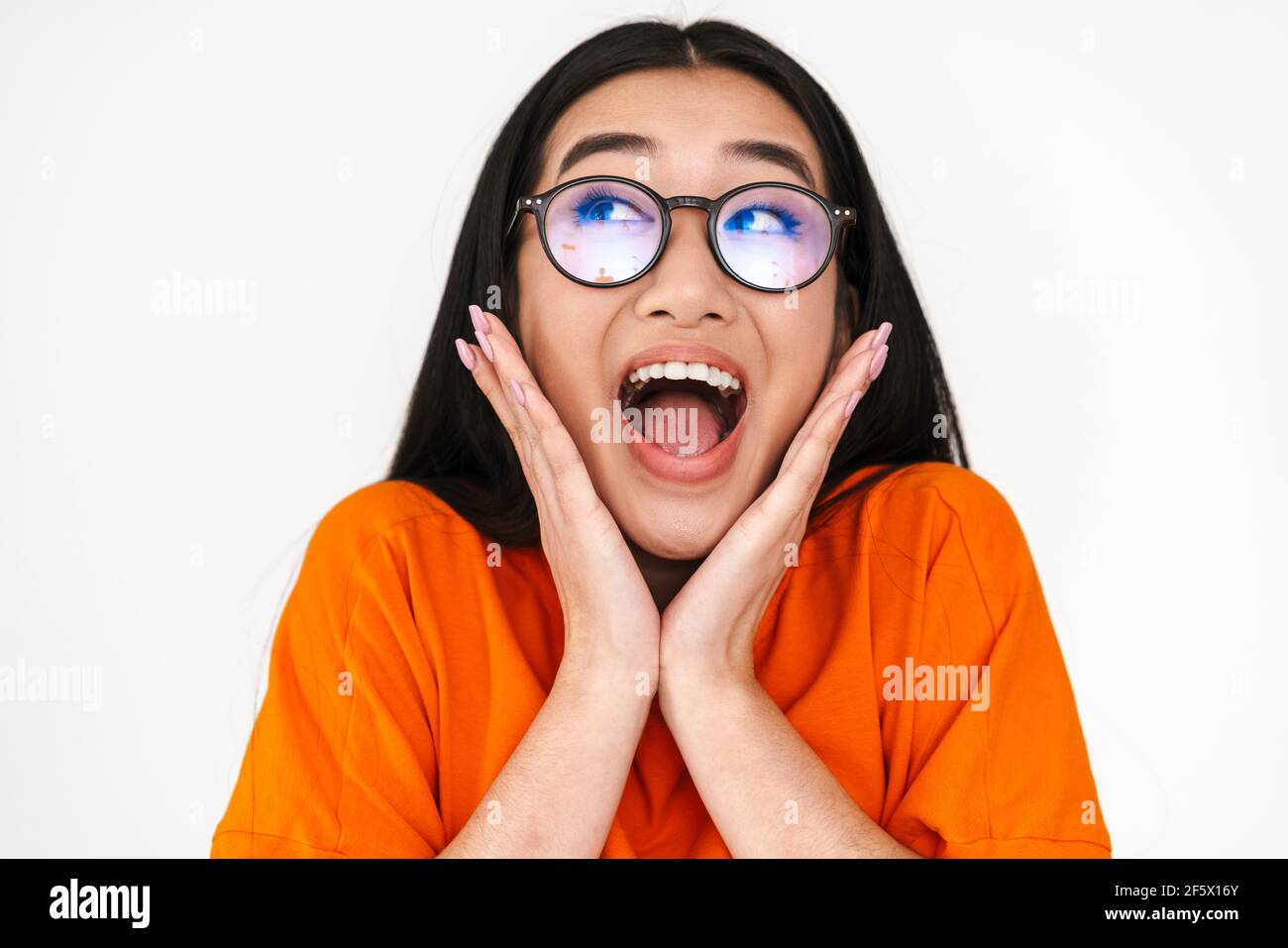 Asian excited student girl in eyeglasses expressing surprise on camera ...