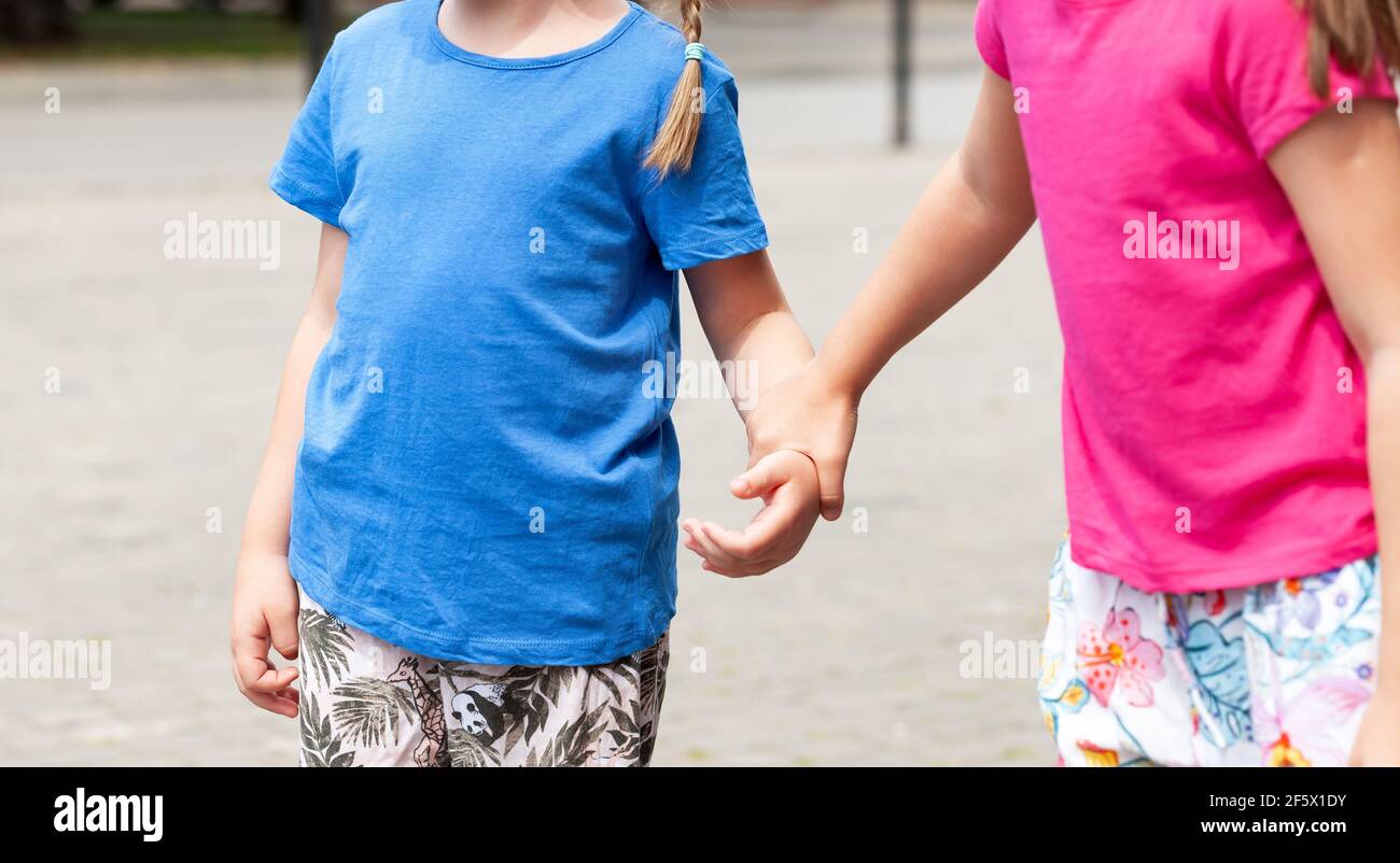 Two anonymous school age children, sisters, siblings together, one girl ...