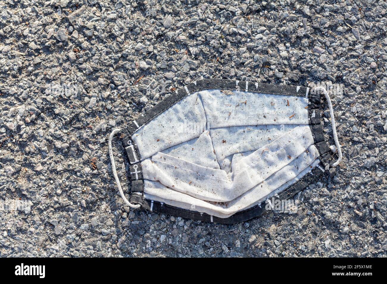 Abandoned old trampled dirty used protective face mask thrown, laying ...