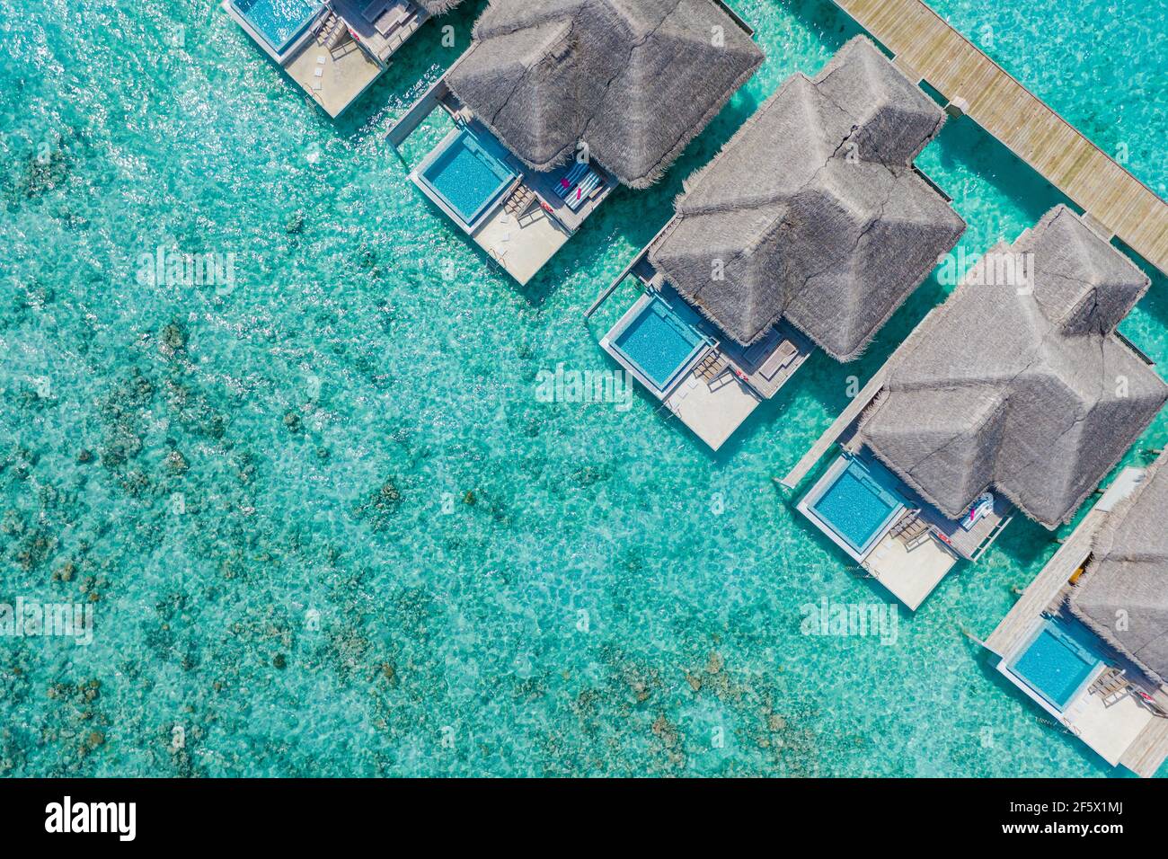 Aerial view of Maldives island, luxury water villas resort and wooden ...
