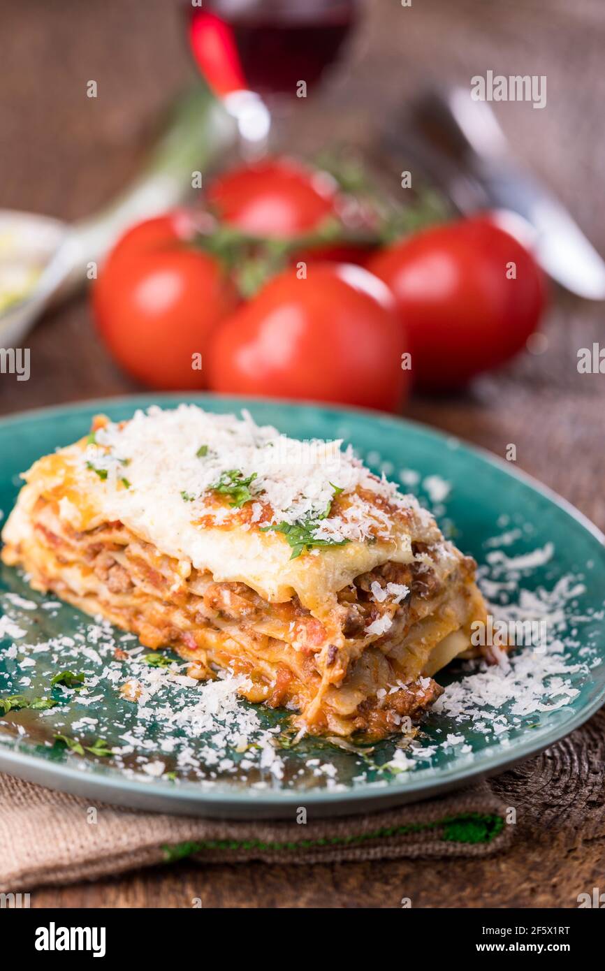 portion of lasagna on a green plate Stock Photo - Alamy